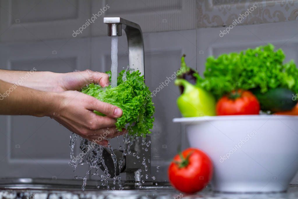 Mujer lavando verduras en la cocina en casa. Verduras frescas para ...