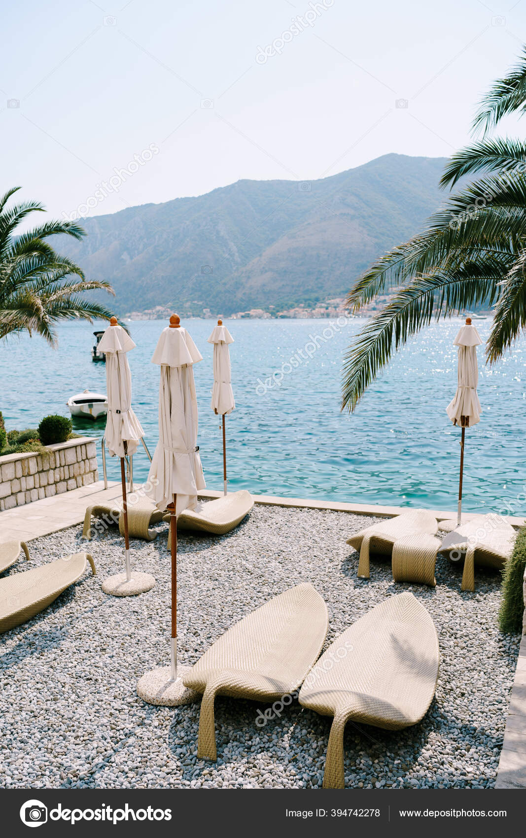 Plastic beach loungers on a pebble beach. Kotor Bay in Montenegro, the ...