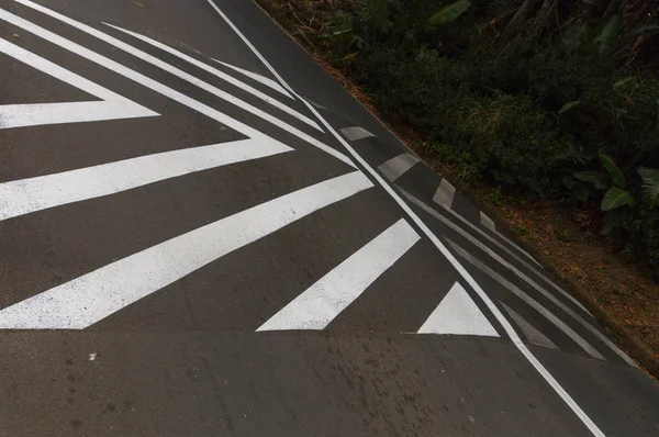 A side view of a speed bump one side newly painted and the other to ...