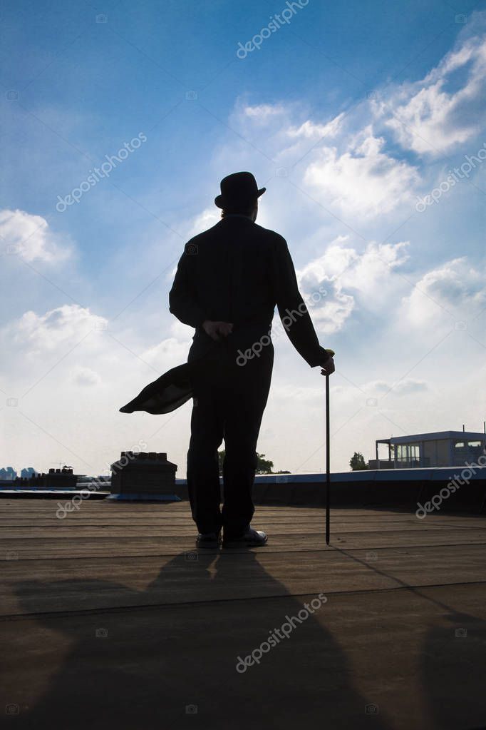 silueta de un caballero elegante que lleva una cola larga con un bastón ...