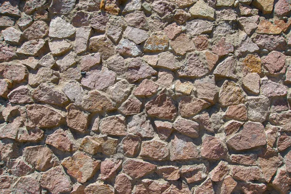 Texture red stones. Wallpaper red granite. The wall is lined with red ...
