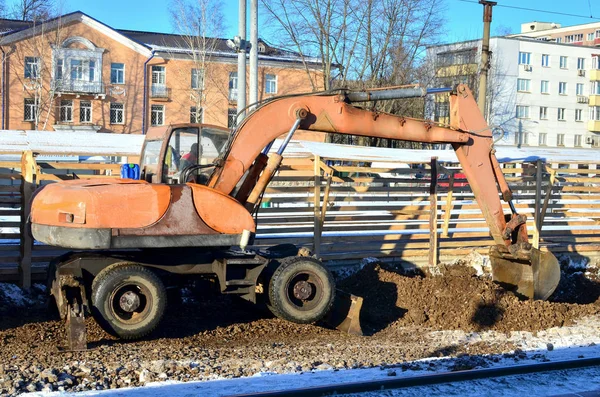 Excavator digging machine digs earth with stones with an iron ladle ...