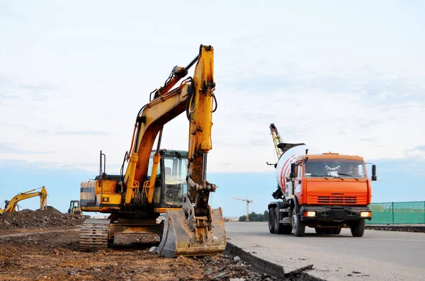 Excavator with a large iron bucket on a construction site during road ...