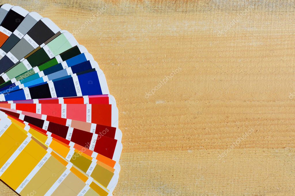 Paleta de colores RAL extendida sobre una tabla de madera 2022