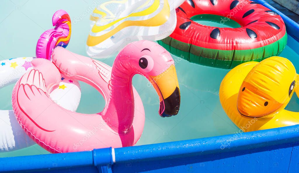 Los círculos inflables de los niños nadan en la piscina. Verano ...