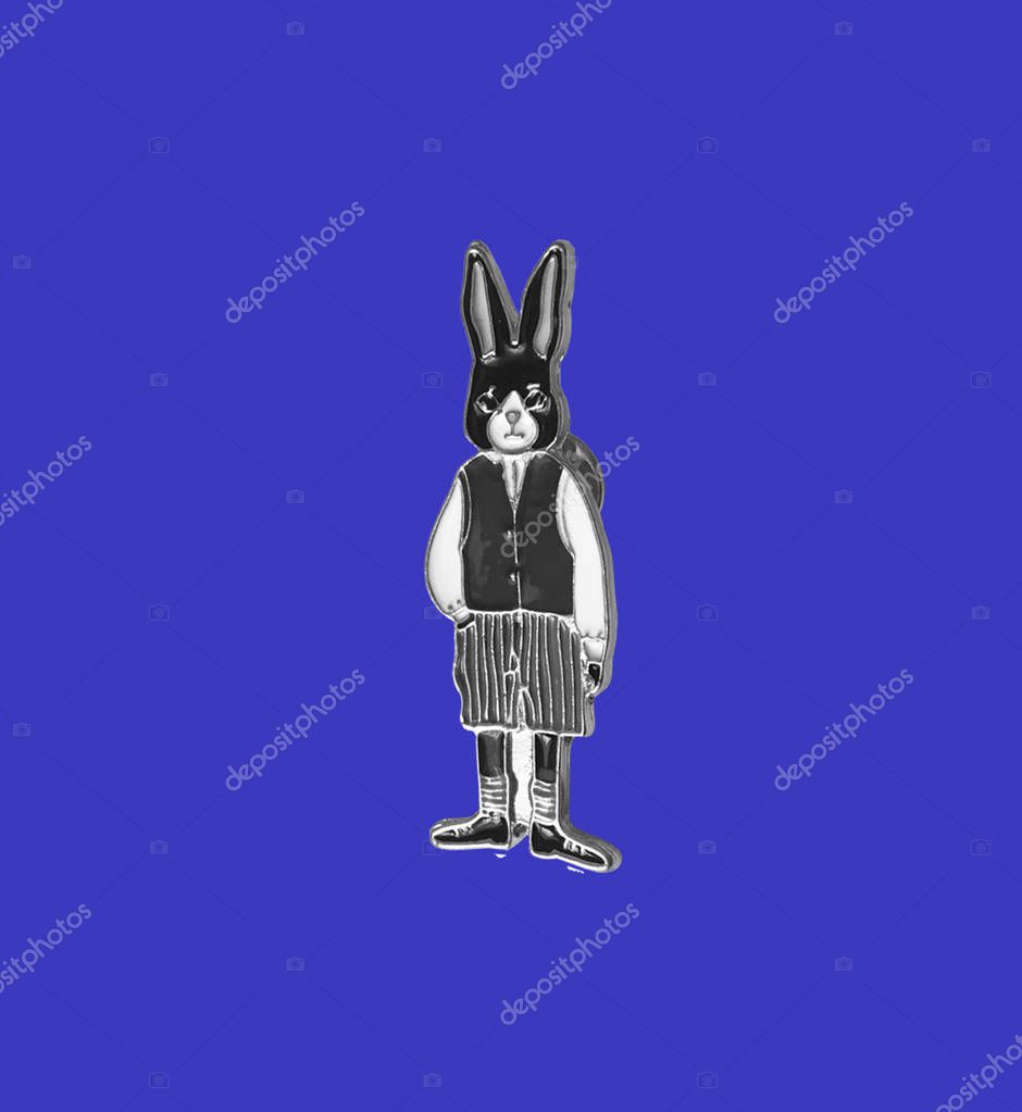 Pin de conejo en un traje sobre un fondo azul. Conejo blanco y negro ...