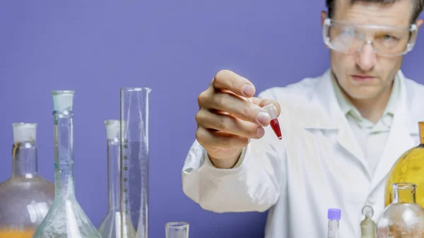 Laboratory assistant putting test tubes into the holder. Chemical ...