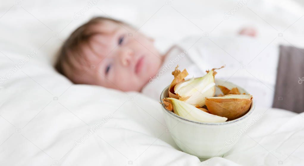 El bebé es tratado con aceites esenciales de cebolla en casa, en cama. 2023
