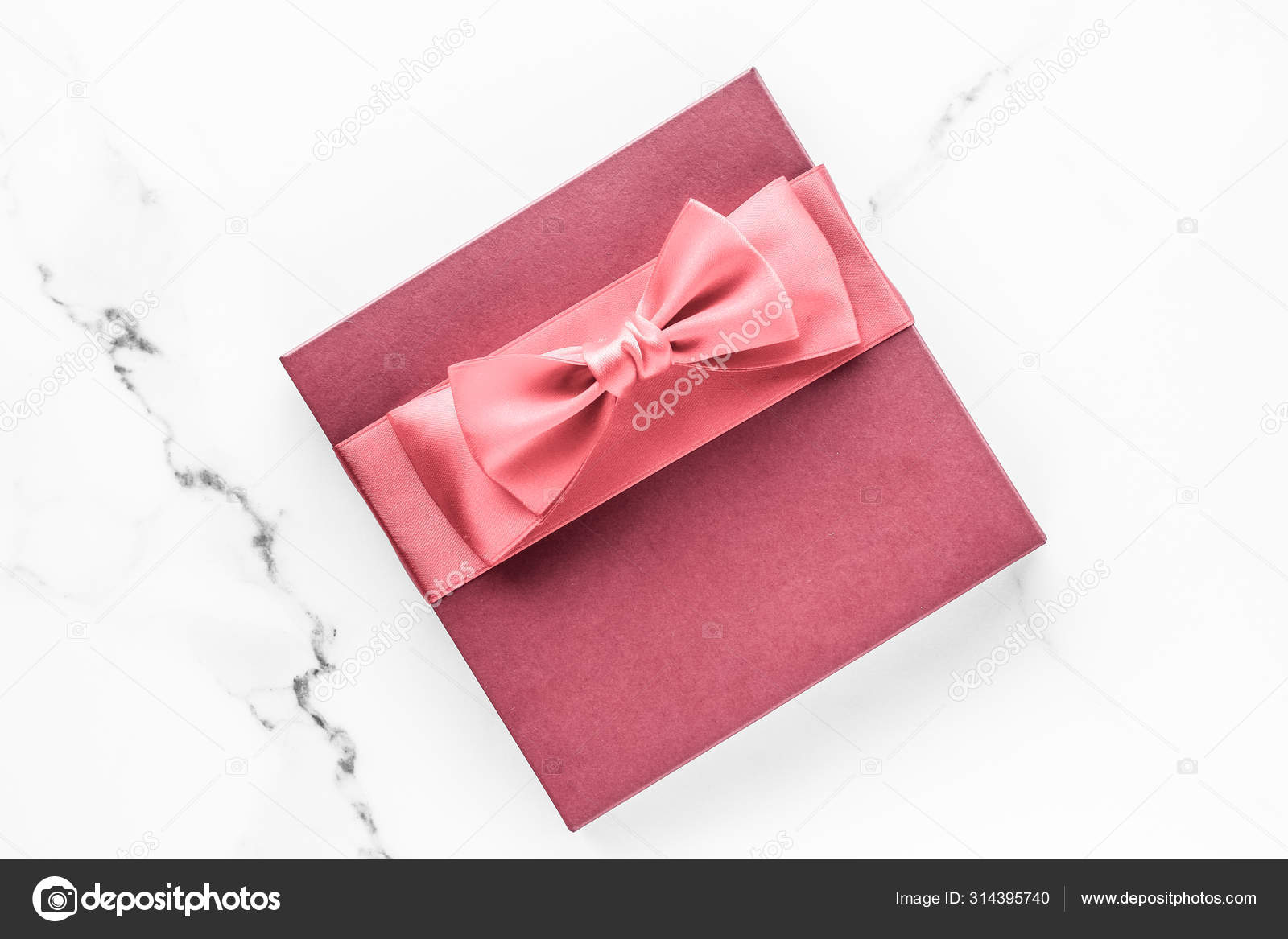 Coral gift box with silk bow on marble background, girl baby sho ...