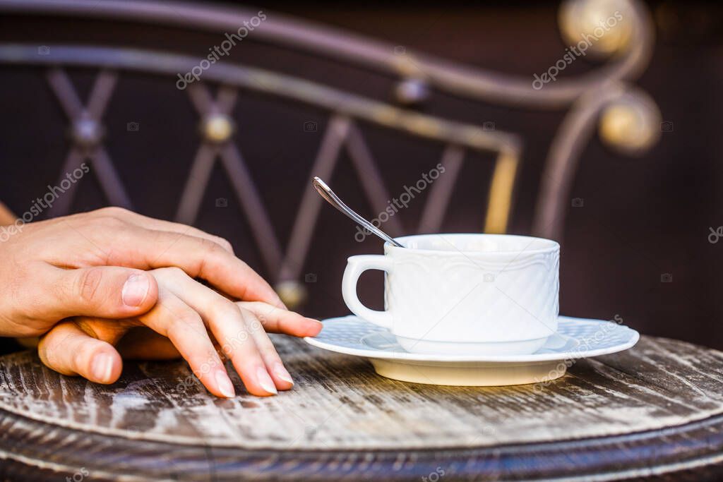 Un par de manos, una taza de café caliente. Pareja disfrutando del café ...