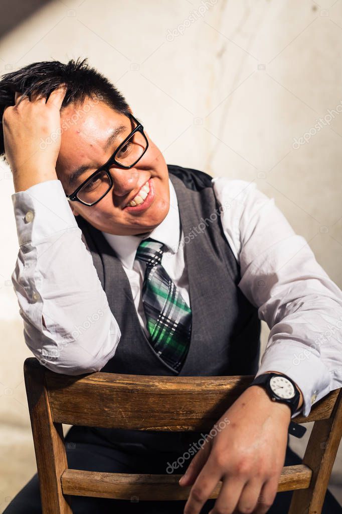 Joven hombre transgénero en ropa formal posa en una ubicación urbana ...