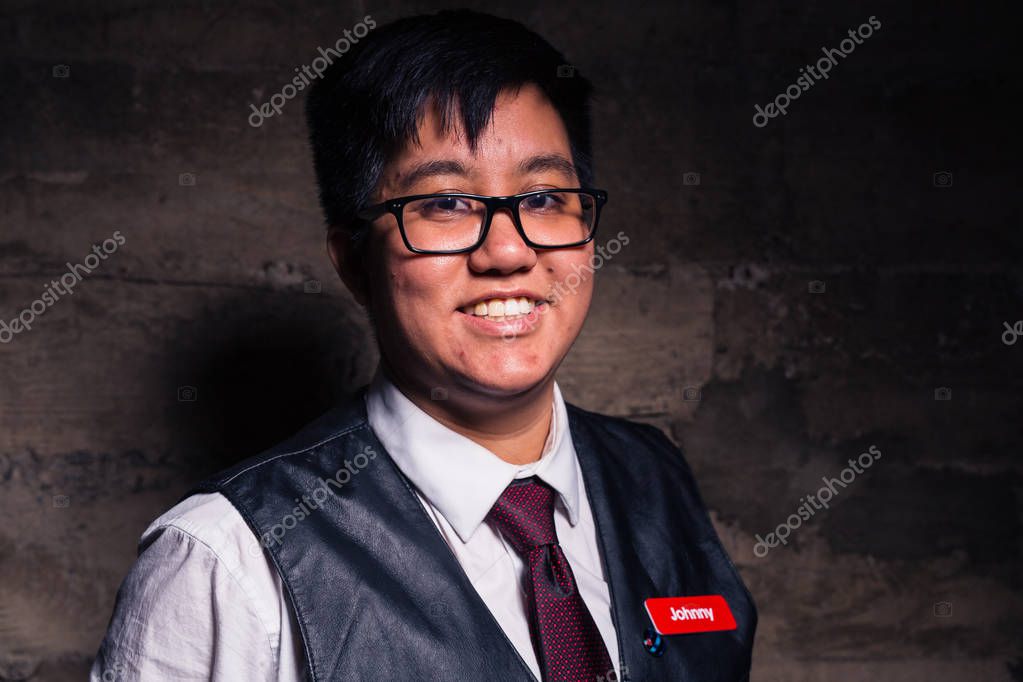 Joven hombre transgénero en ropa semi formal con un chaleco de cuero ...