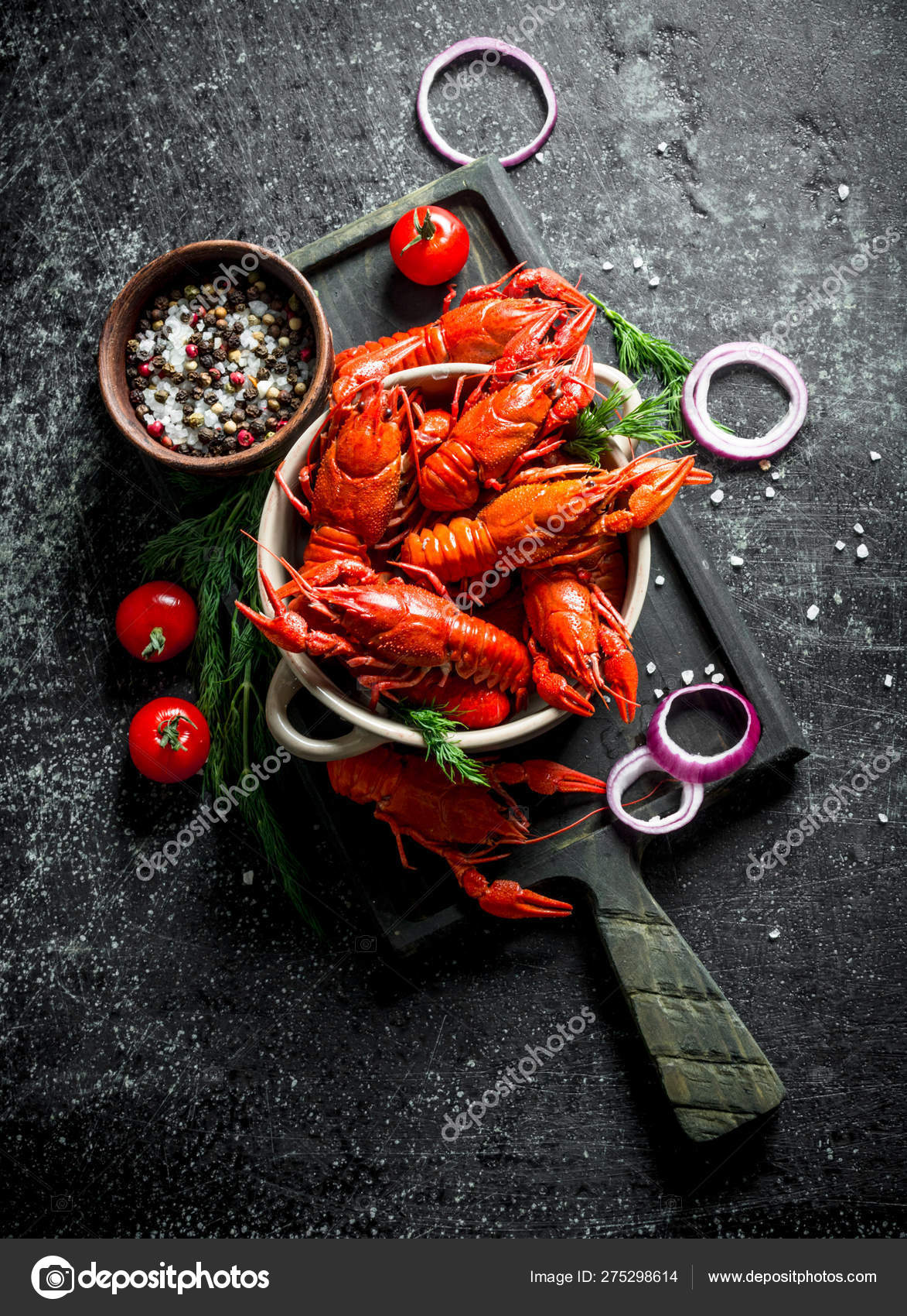Boiled crayfish on a cutting Board with onion rings, tomatoes and ...