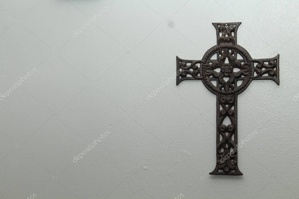 una cruz de metal sobre un fondo gris que se muestra completamente con ...