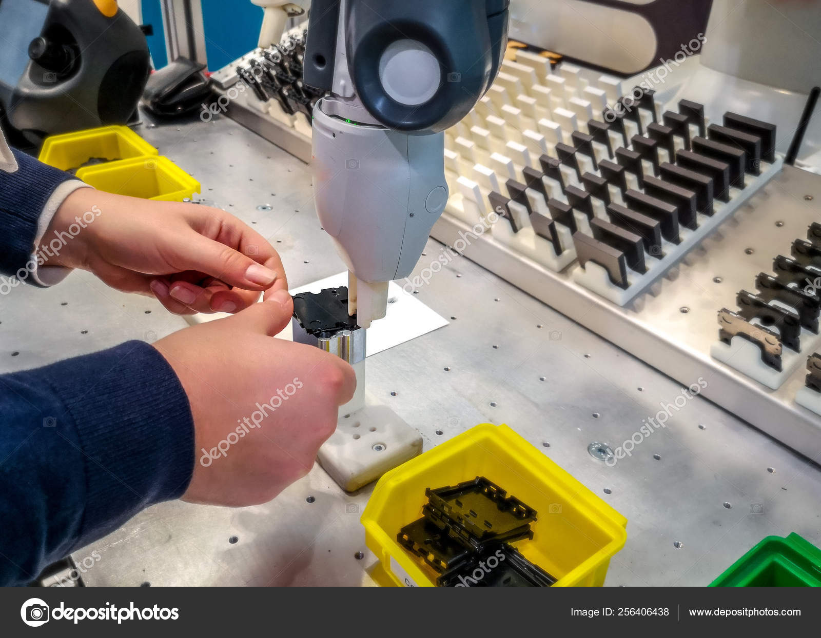 Caucasian female operator standing at an assembly workstation with a ...