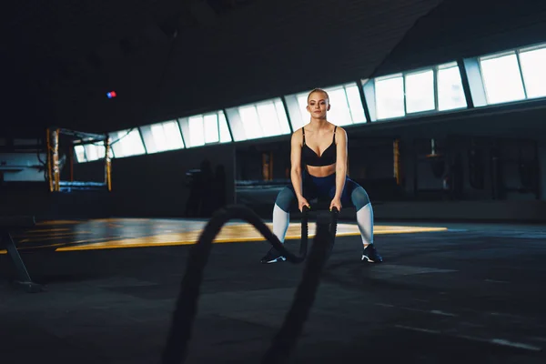 Full length wide angle shot of a young woman working out with ba ...