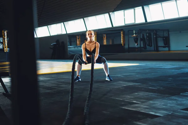 Full length wide angle shot of a young woman working out with ba ...