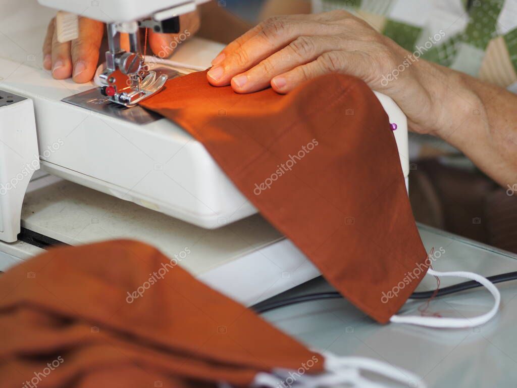 Mujer utilizar la máquina de coser para coser la cara máscara médica de ...