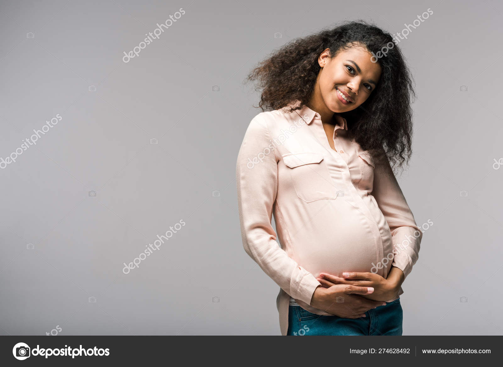 Smiling Pregnant African American Woman Touching Belly While Standing