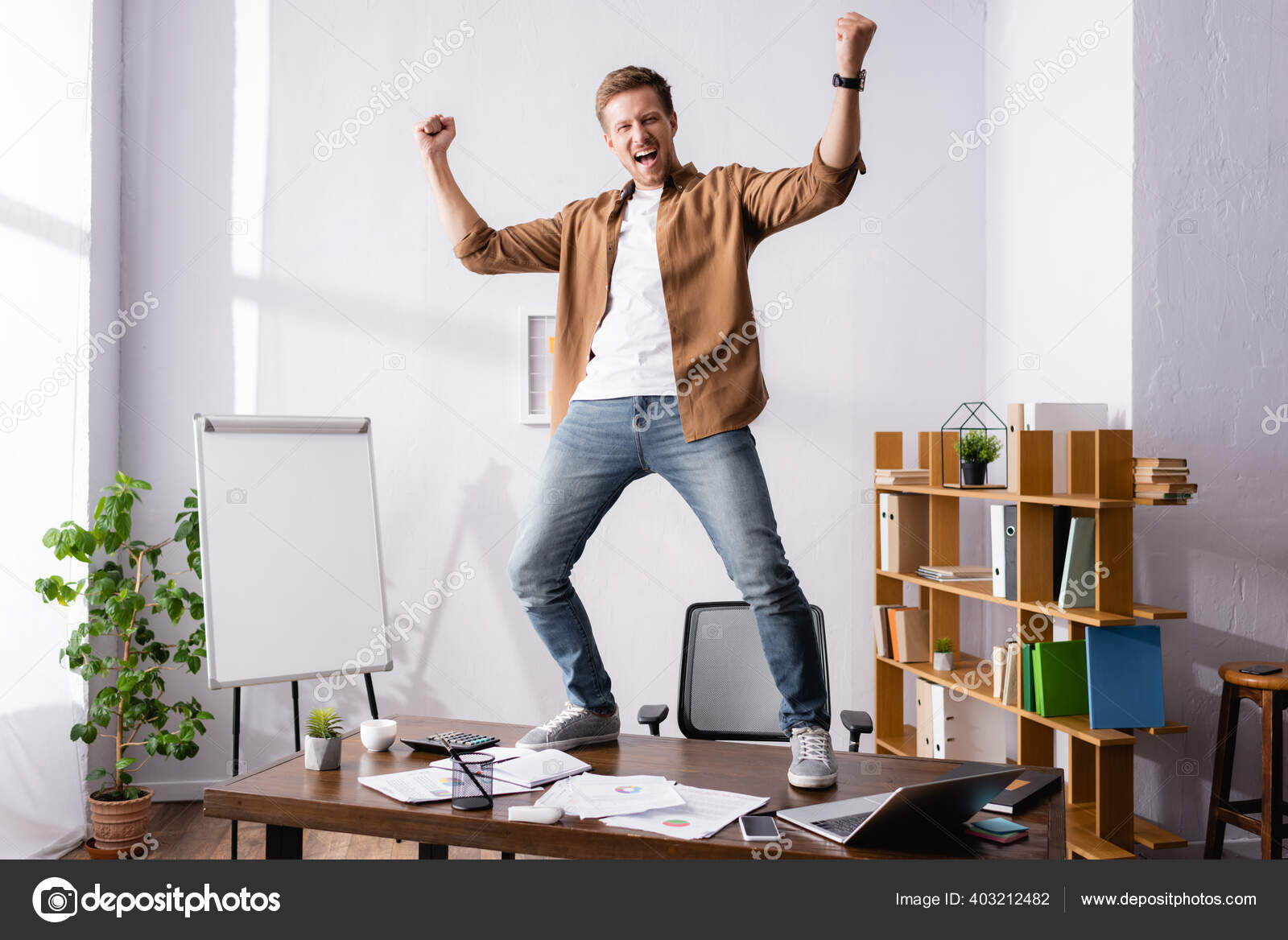 Businessman Showing Yeah Gesture While Standing Gadgets Papers Office ...