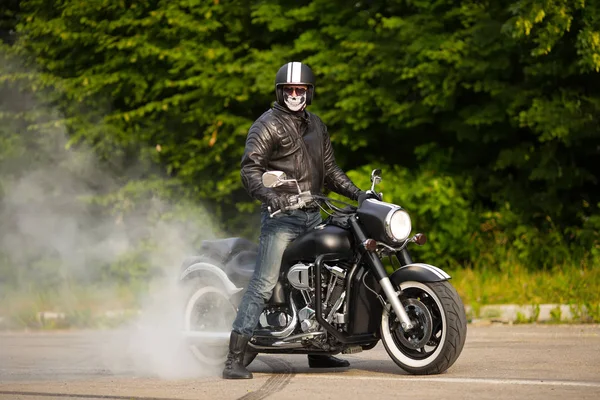 biker in mask and helmet sitting on big bike on road - Stock Image ...