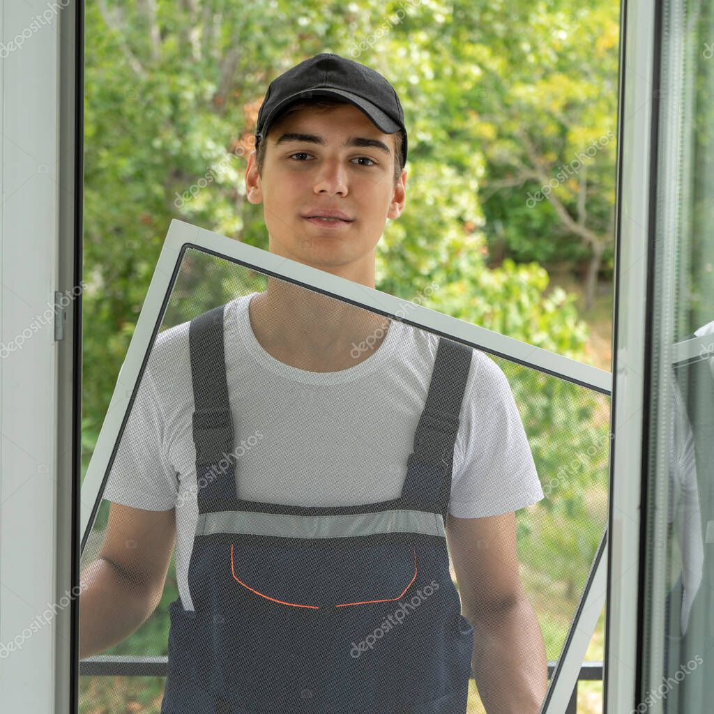 Trabajador instala mosquitero. Protección contra insectos Vista desde ...