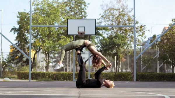 Assisted poses. Appearling loving man and woman practicing yoga and ...