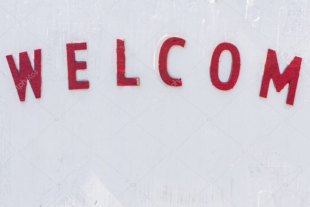 Welcom sign on white wall #251233476 - Larastock