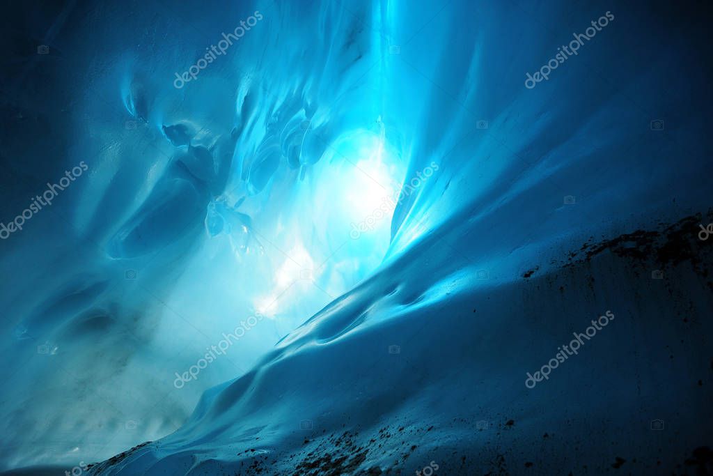 Luz en una cueva de hielo azul con curvas de hielo en la pared, desde ...