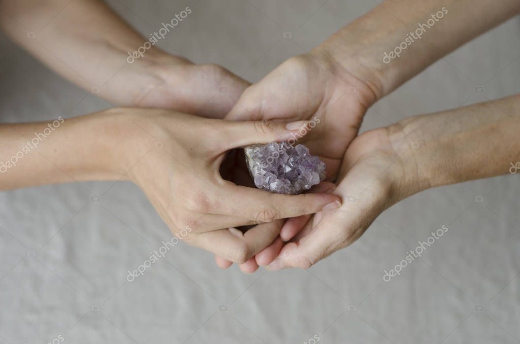 Mujeres manos dando un cristal de amatista en otras mujeres manos en ...