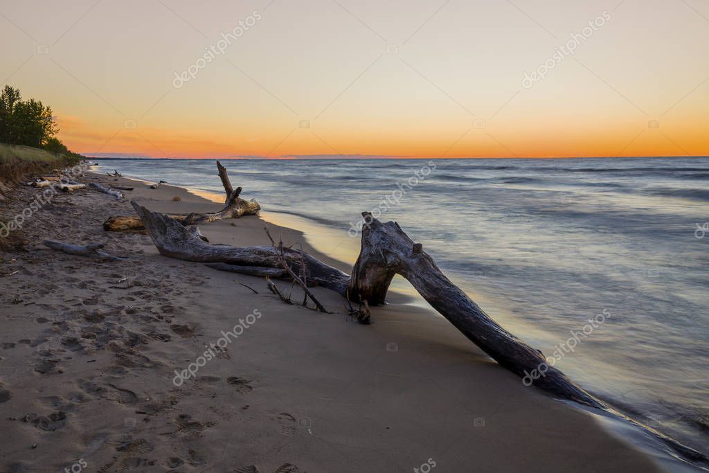 Madera a la deriva en una playa de Lake Huron después del atardecer ...
