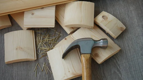 Pequeñas tablas con clavos de hierro. Fondo gris. 2023