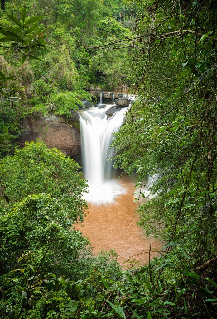 Centrándose en una gran cascada con agua de barro a través de un árbol ...