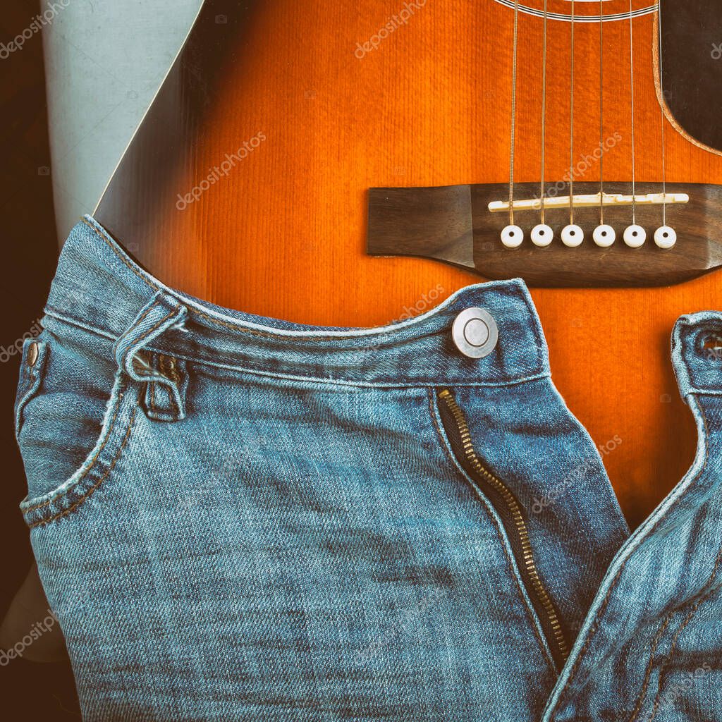 Vaqueros azules se ponen una guitarra acústica, que es similar a las curvas del cuerpo femenino ...