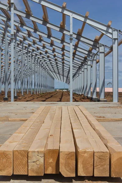 Wooden beams for steel structure for further construction. Metal frame ...