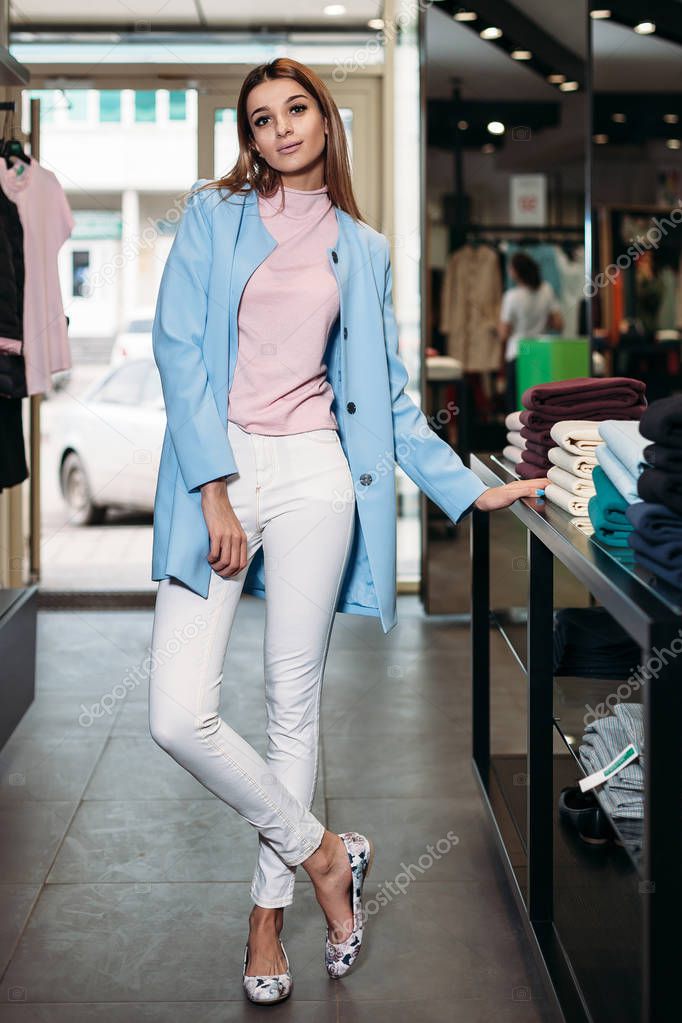 Hermosa modelo morena chica en ropa elegante, posando en la tienda de ...