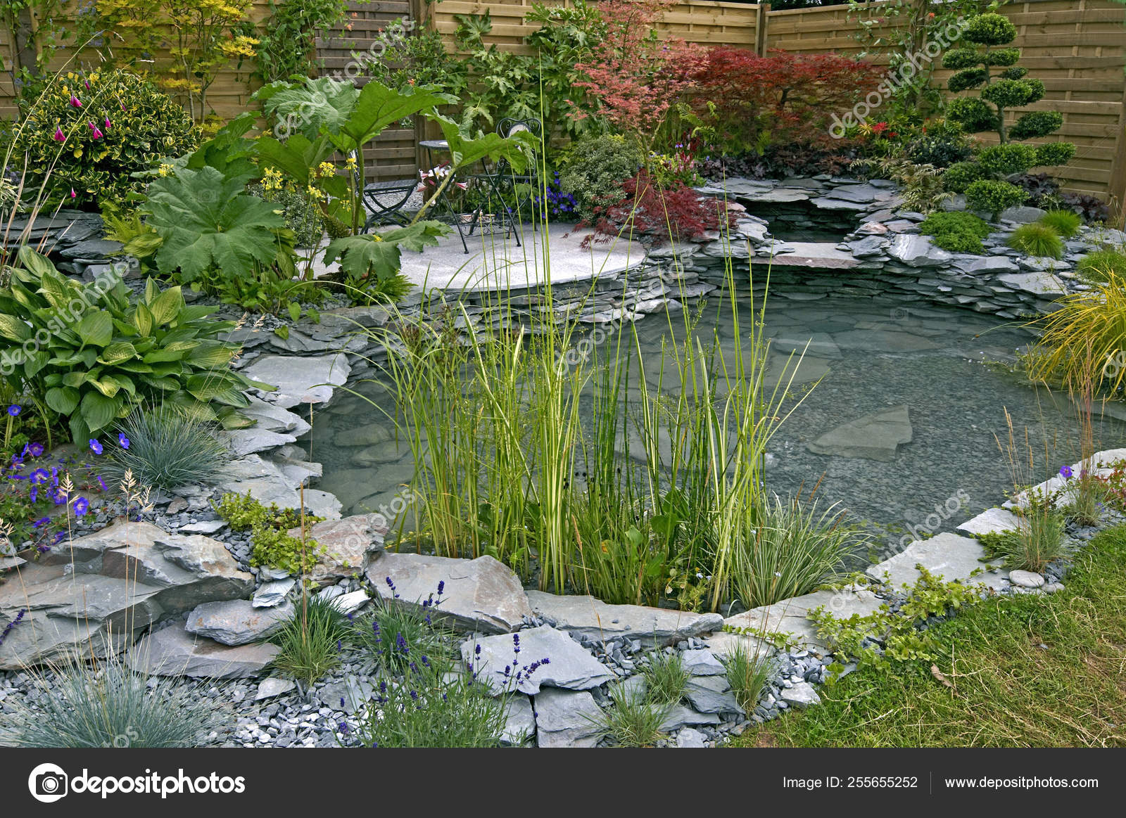 Interesting water feature with pond, rough loose rockery — Stock Photo ...
