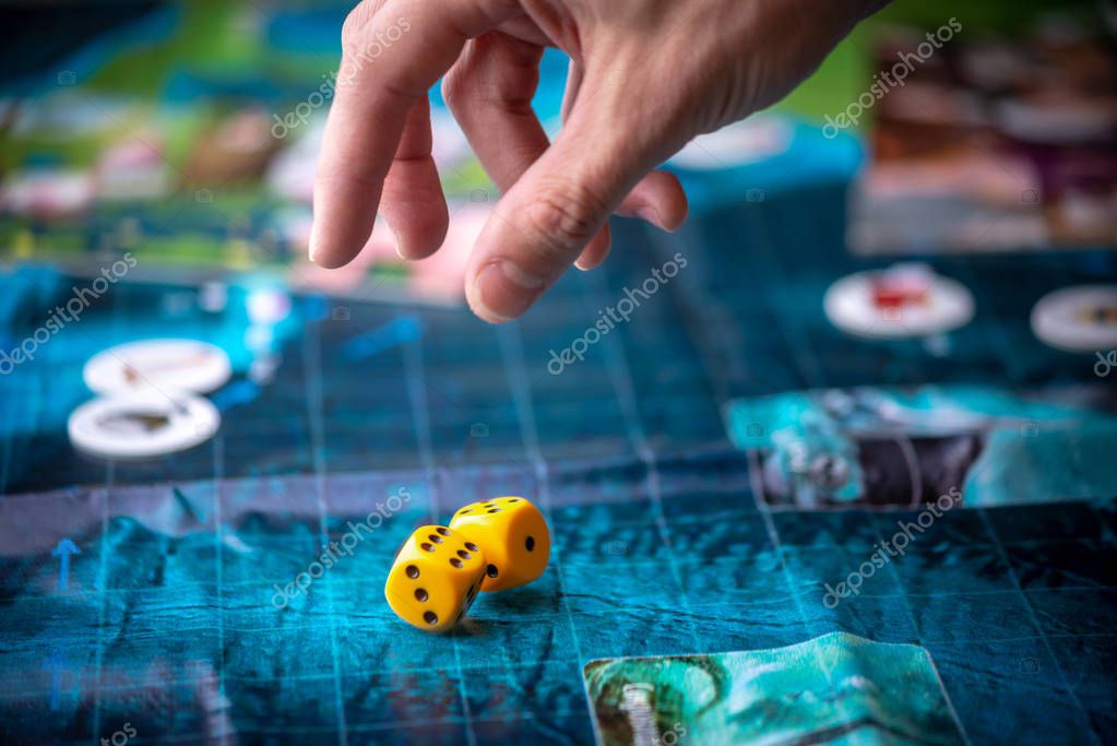 Mano lanza dos dados amarillos en el campo azul del juego de fantasía ...