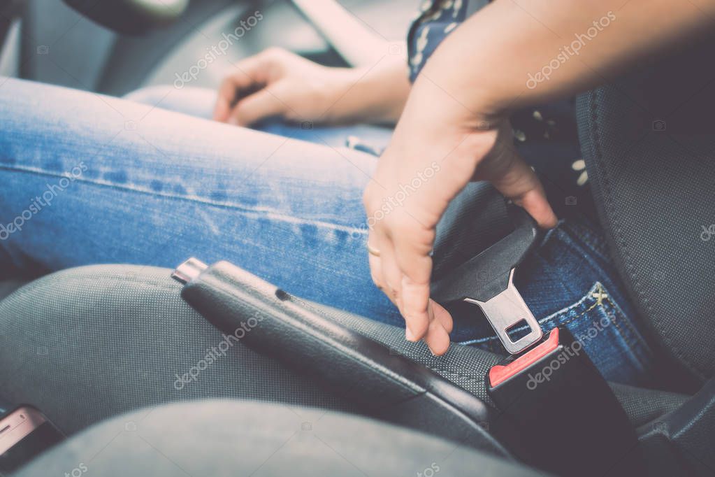 La mano de la hembra sujeta el cinturón de seguridad del coche. Cierre ...