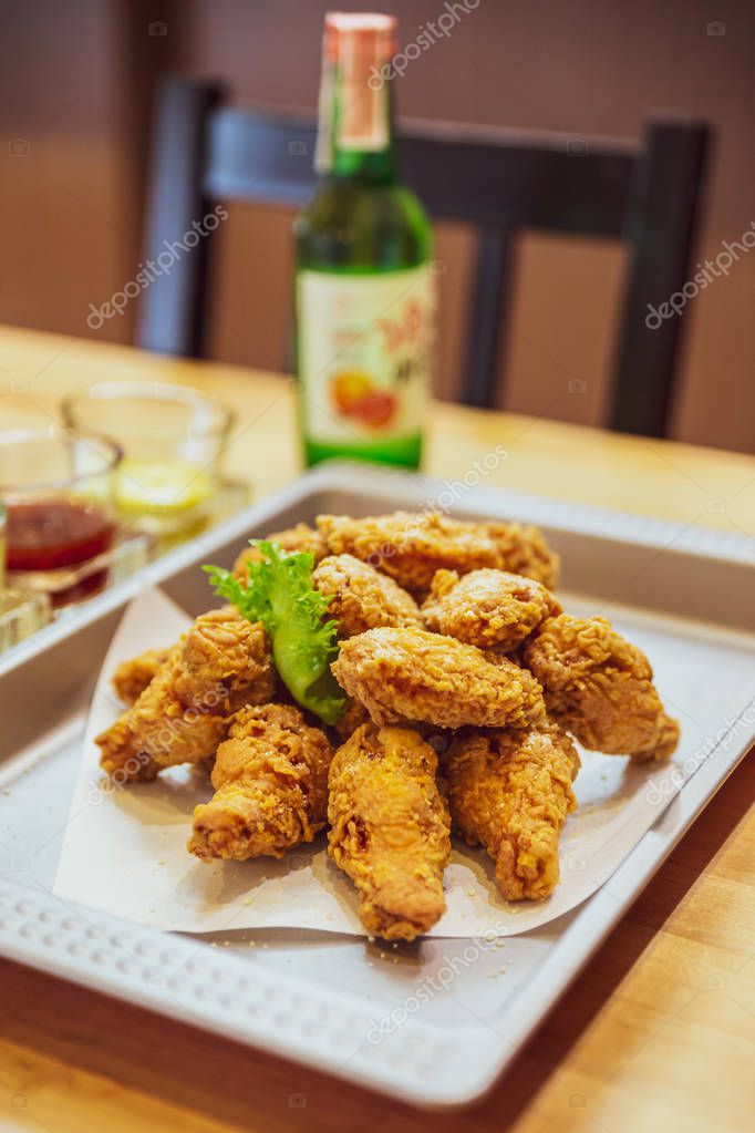 Pollo frito coreano crujiente dorado (Huraideu-Chikin básico) servido con escabeche y soju. En ...