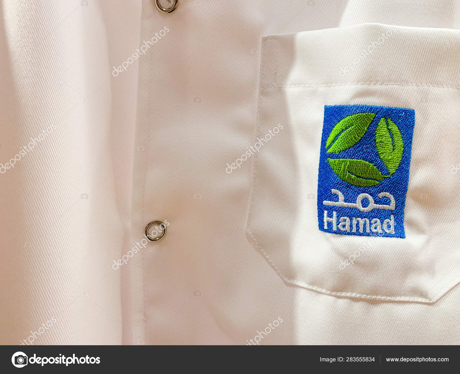 White workwear of a doctor or assistant with Hamad logo in Arabic and ...