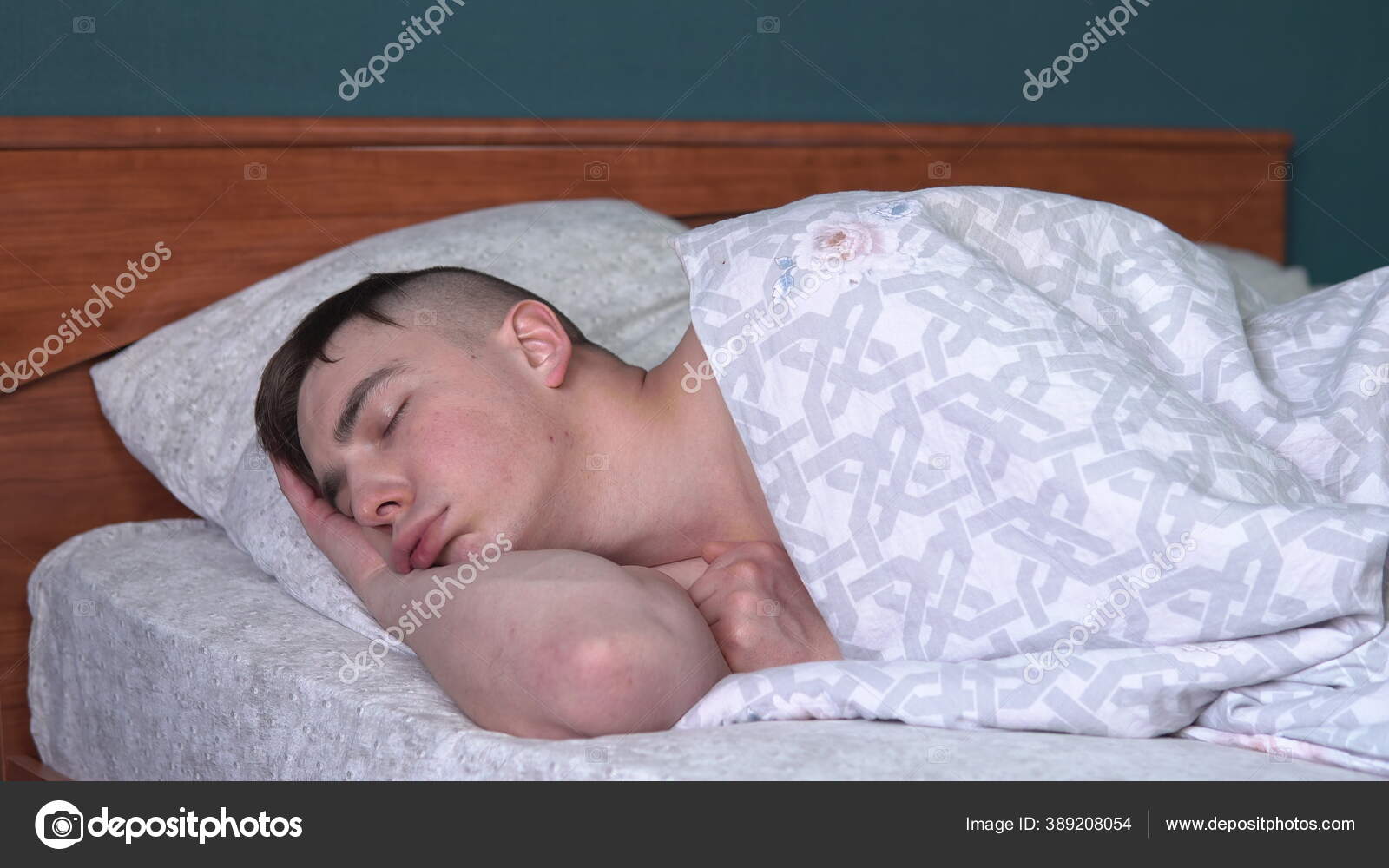 A young man is sleeping with a funny expression on his face. A man lies ...