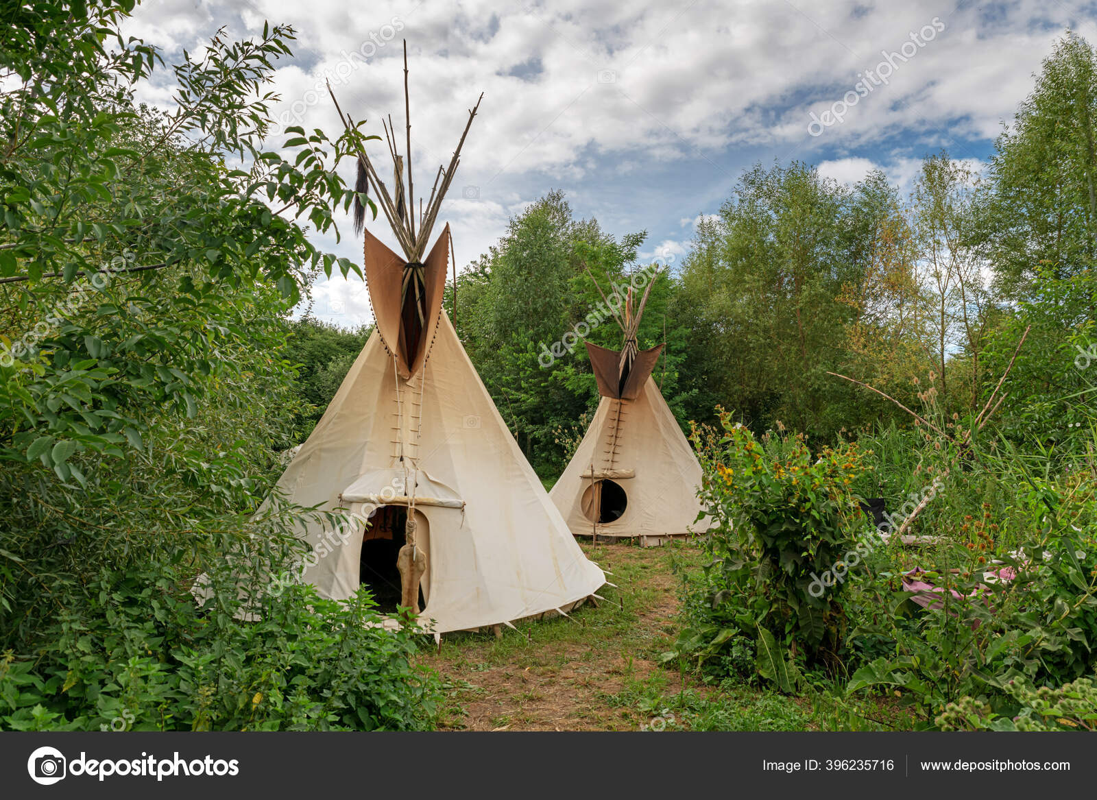 Two Indian tipis stand in a meadow between trees and bushes Stock Photo ...