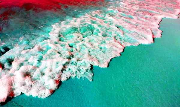 The foamy transparent sea wave rolls on gentle sand. Shore of the sea ...