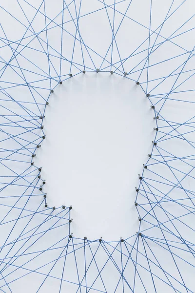 Human head shape made from a large grid of pins connected with s ...