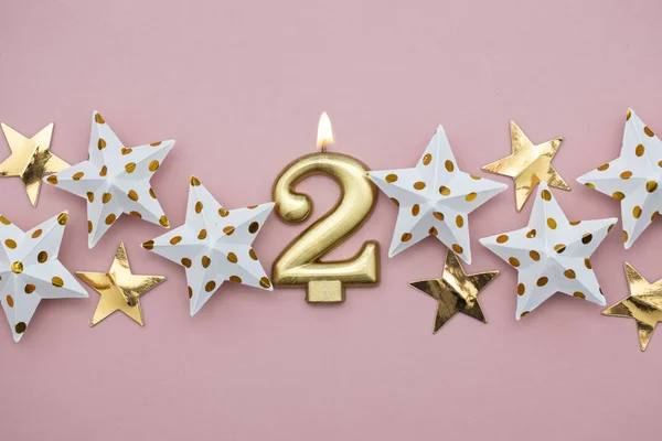Number 20 gold candle and stars on a pastel pink background Stock Photo ...