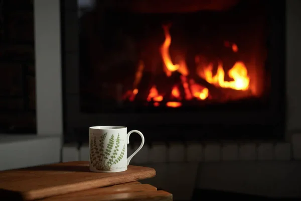 cup of tea. fire in the fireplace. concept of home comfort and warm ...