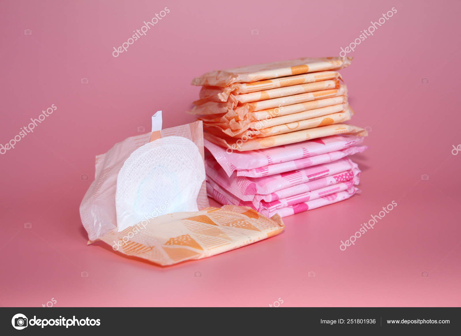 On a rose background are several sanitary pads in individual packaging ...