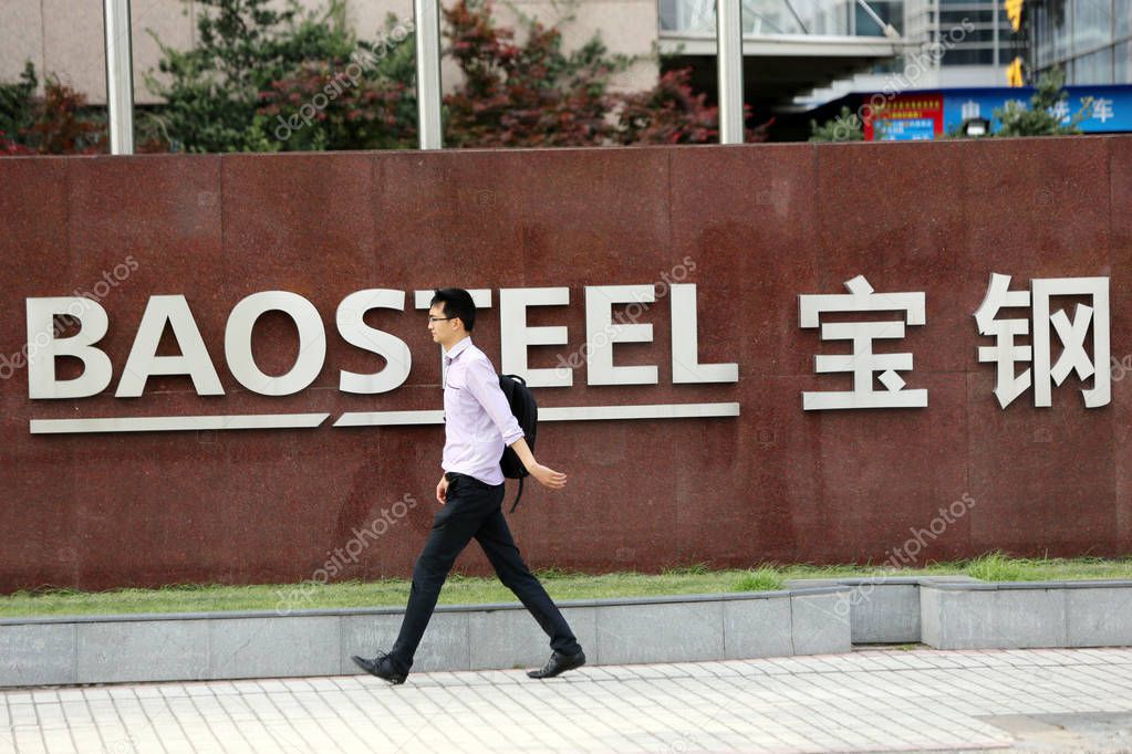 Un peatón pasa por la sede de Baoshan Iron and Steel Co., Ltd ...