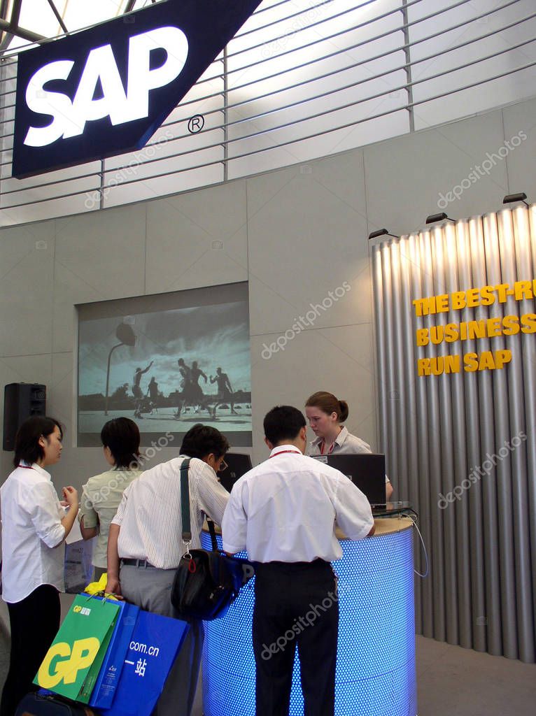 Clientes de servicio del personal chino en el stand de SAP durante una ...